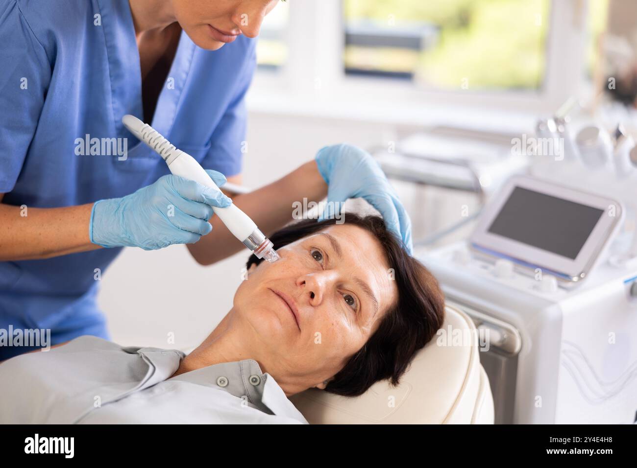 Mature woman getting facial deep hydration procedure from experienced ...