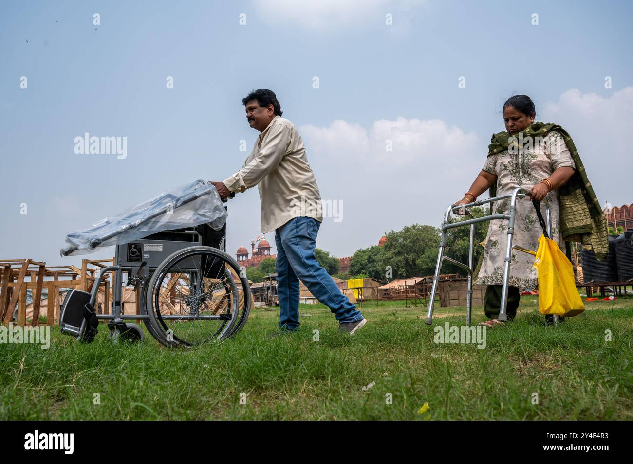 A man with a handicap wheelchair and a woman with a handicap walker ...