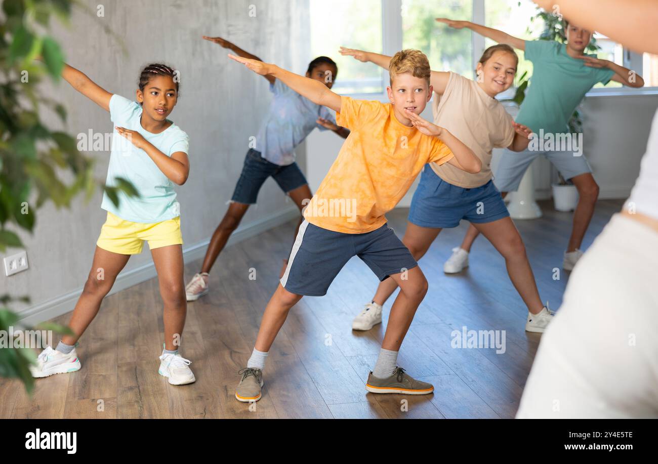 Boy moves in dance lesson and repeats movements behind unrecognizable ...
