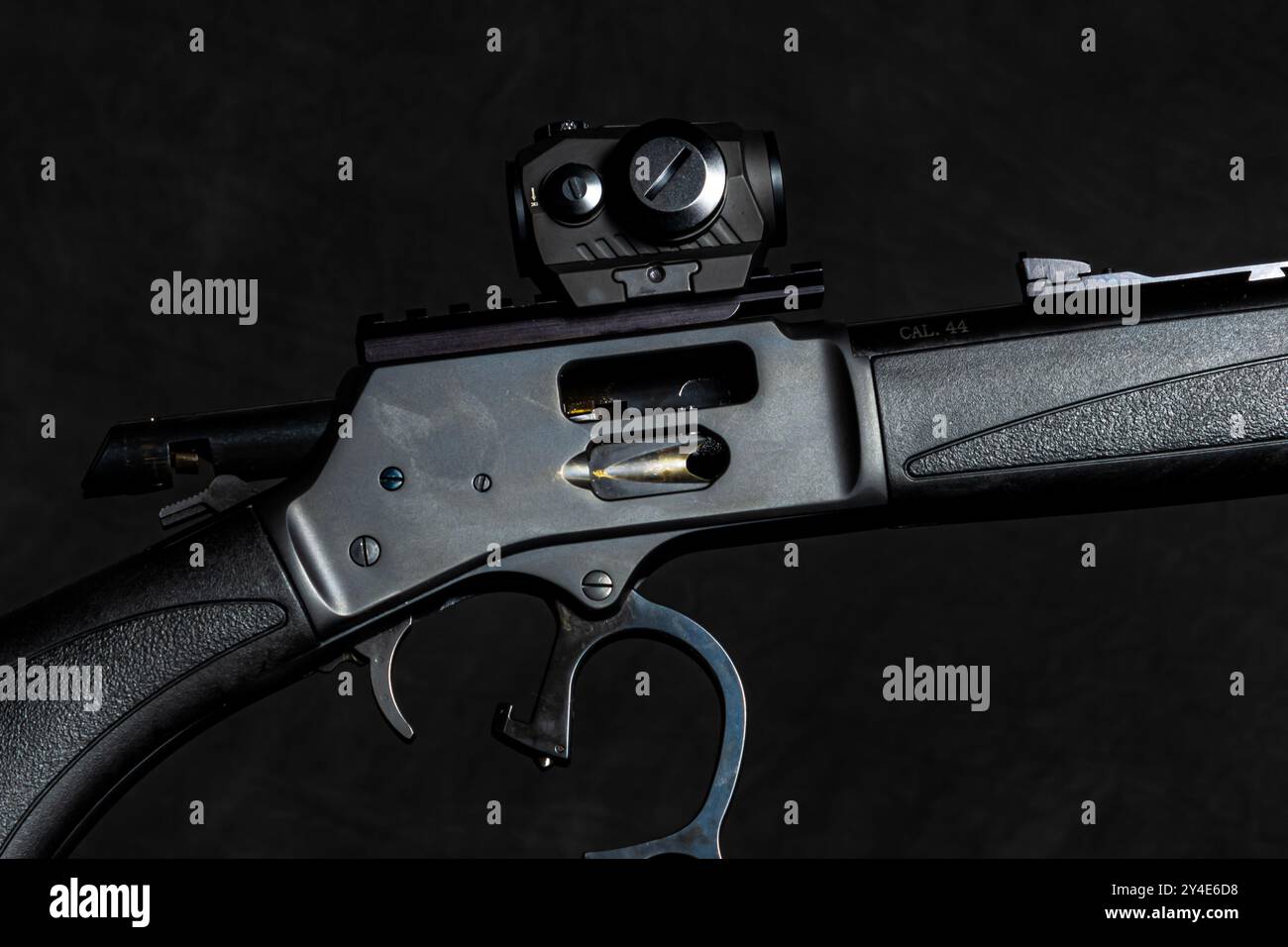 SIde gate on a lever action rifle with the bolt open and a red dot ...