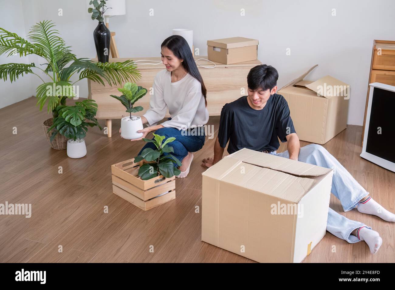 Practical Home Setup Couple Arranging Plants and Boxes Stock Photo - Alamy