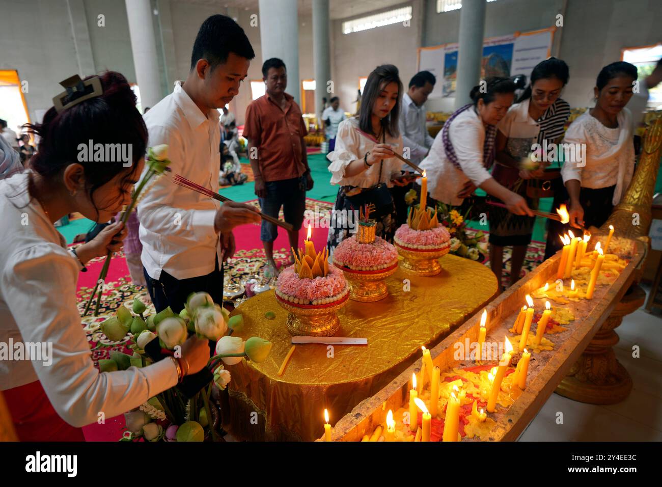 Cambodian devotees light candles and incense sticks during a ...