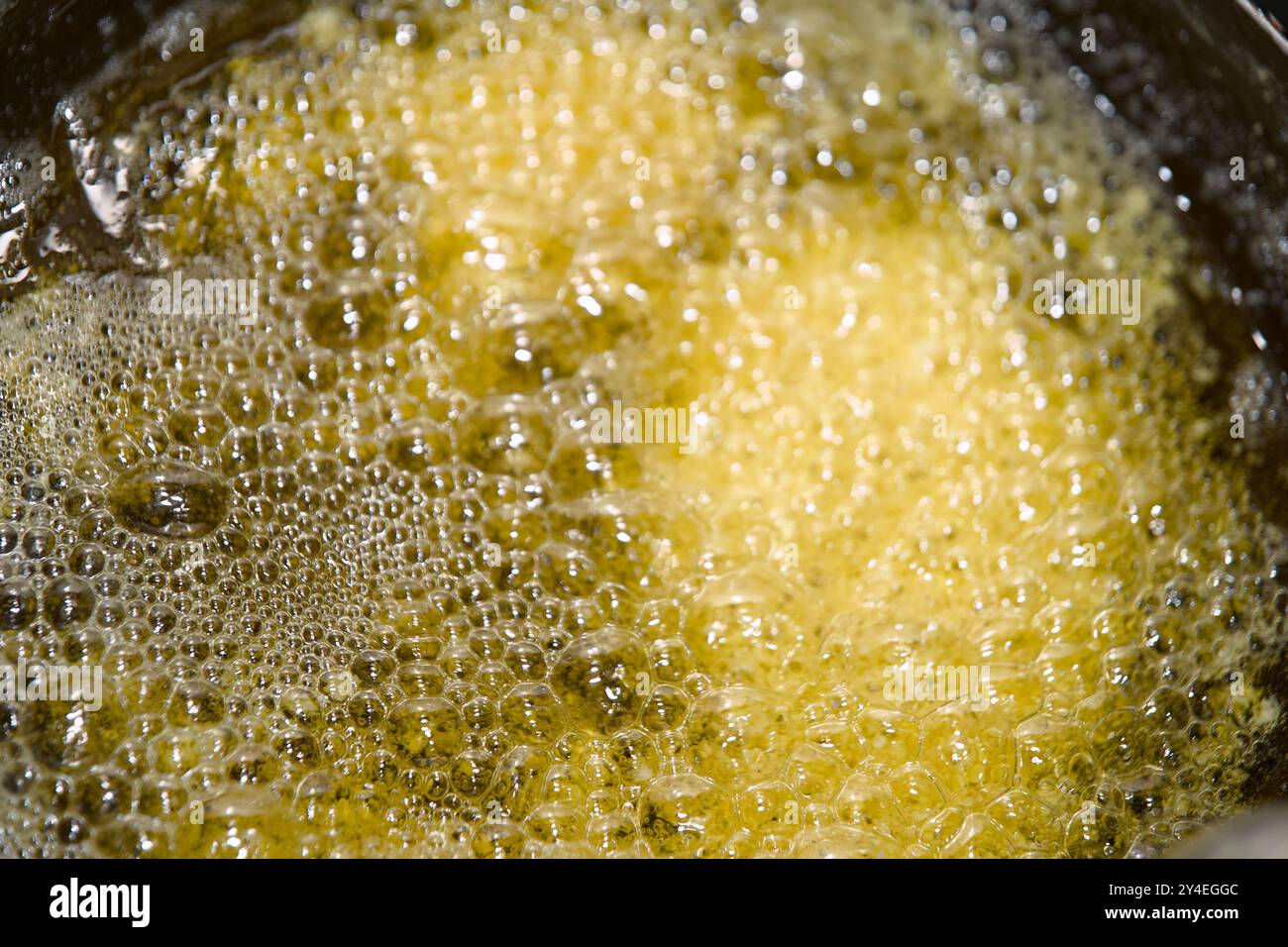 Abstract texture of sizzling hot Ghee with golden bubbles, perfect for ...