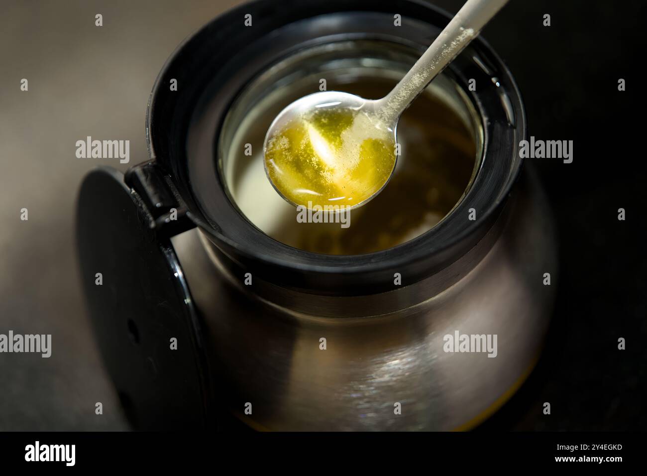 Spoonful of melted ghee, a healthy cooking fat, being scooped from a ...