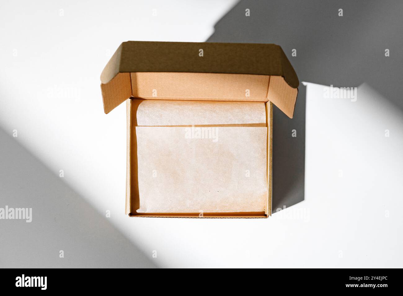 A small, empty cardboard box with unwrapped parchment resting inside on ...
