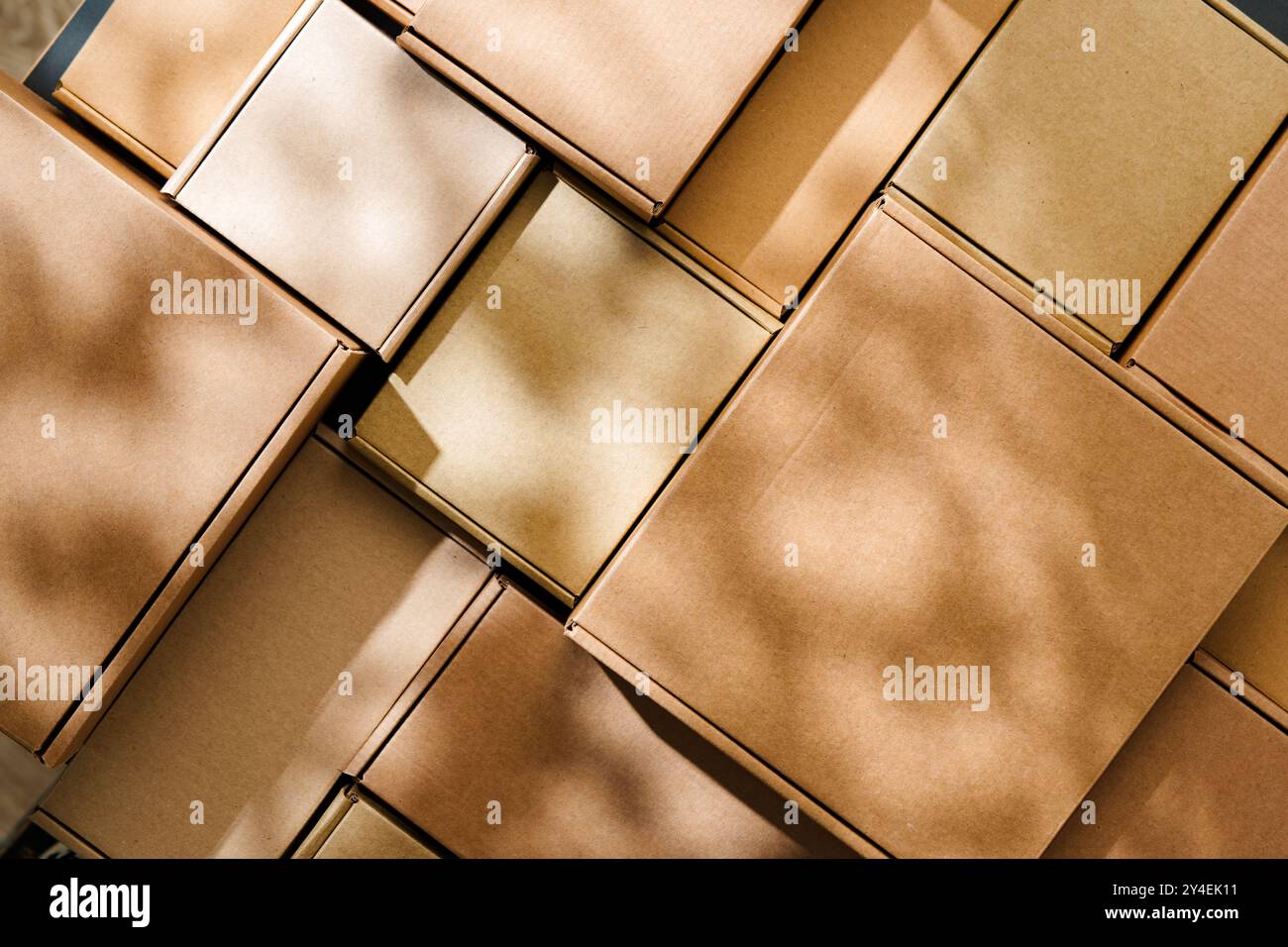 Stacked cardboard boxes arranged in a neat pattern under natural light ...