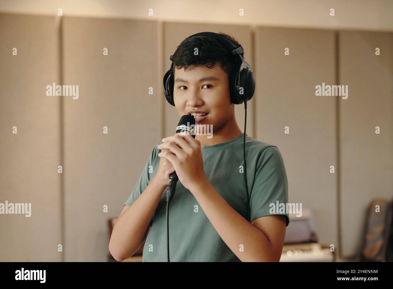 Singing and Holding Microphone in Recording Studio with Headphones ...
