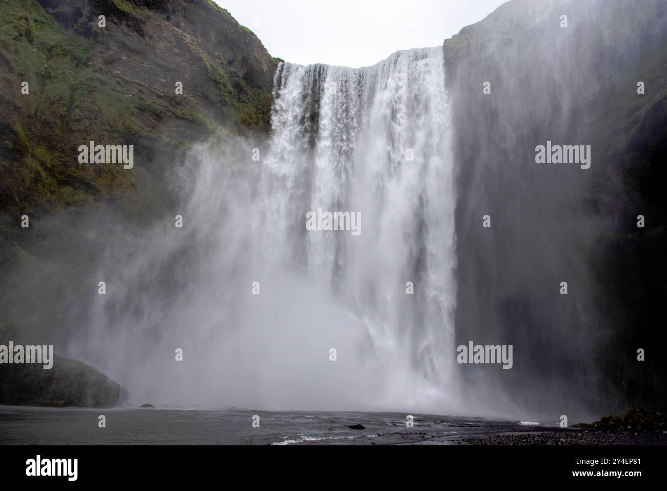 the Skogafoss waterfalls in summer with the green of the mountains and ...