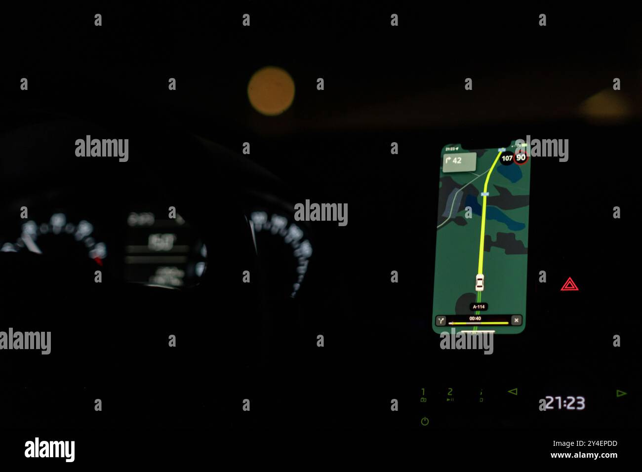 A driver uses a GPS navigation system at night, displaying route ...