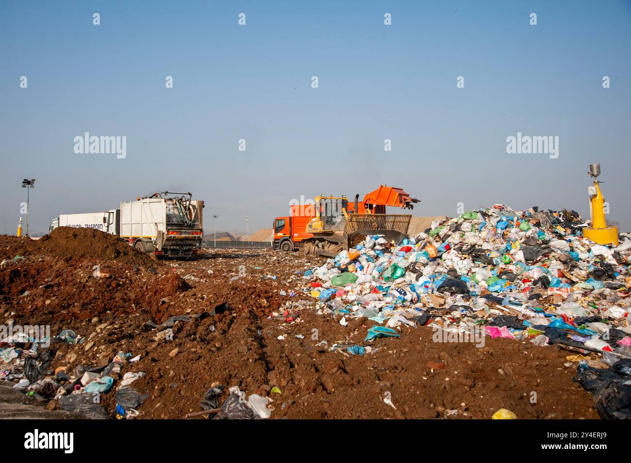 Municipal waste landfill. Workers with trucks and bulldozers at work in ...