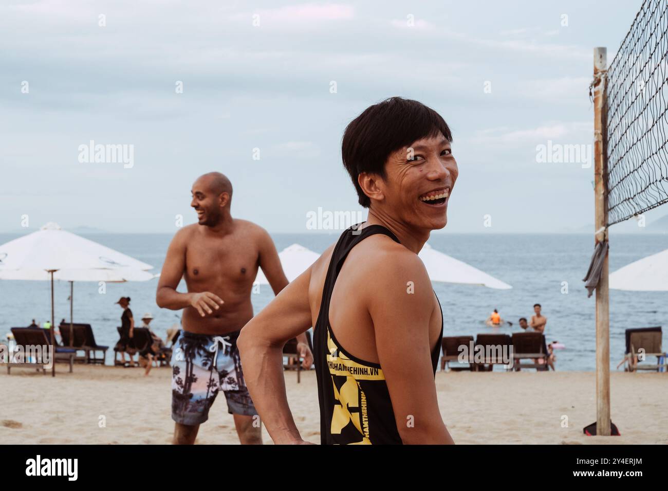 Happy beach volleyball players laugh on the beach by the sea in summer ...