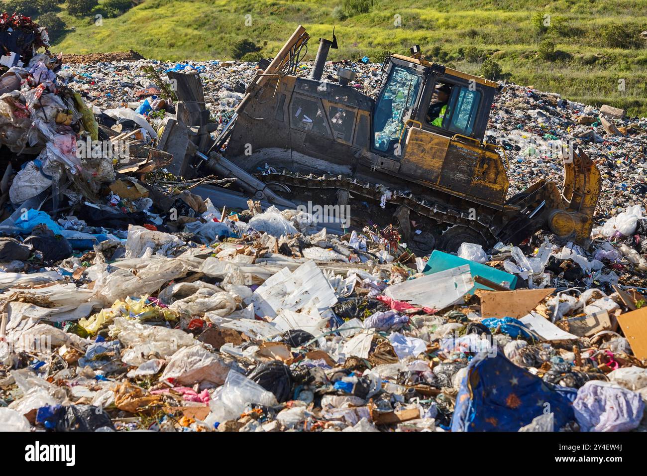 Heavy machinery shredding garbage in an open air landfill. Waste Stock ...