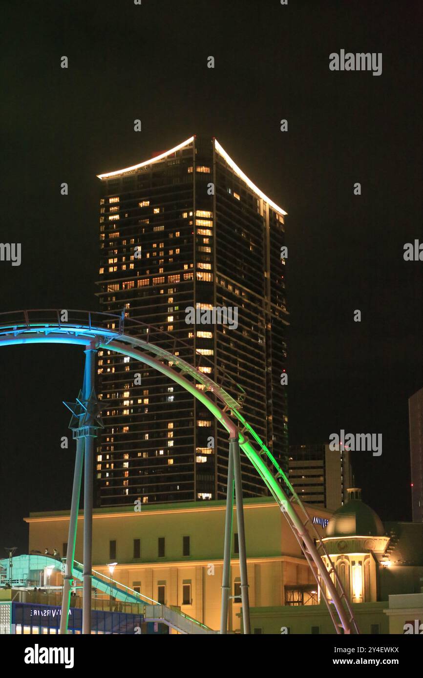 Modern high-rise building with illuminated roller coaster track at ...