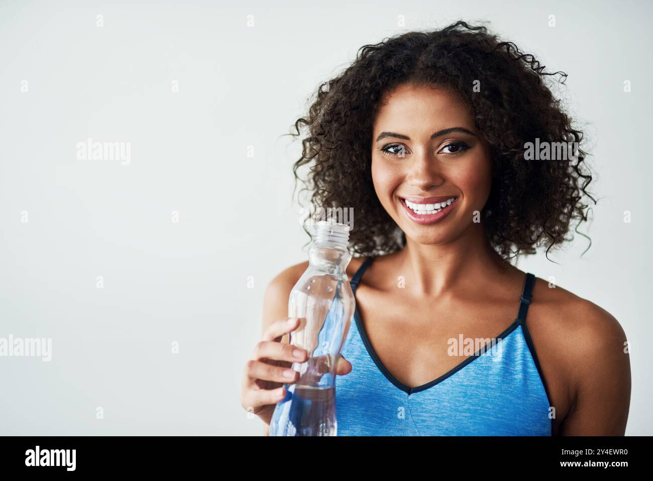 Woman, portrait and water in studio with fitness for hydration, break ...