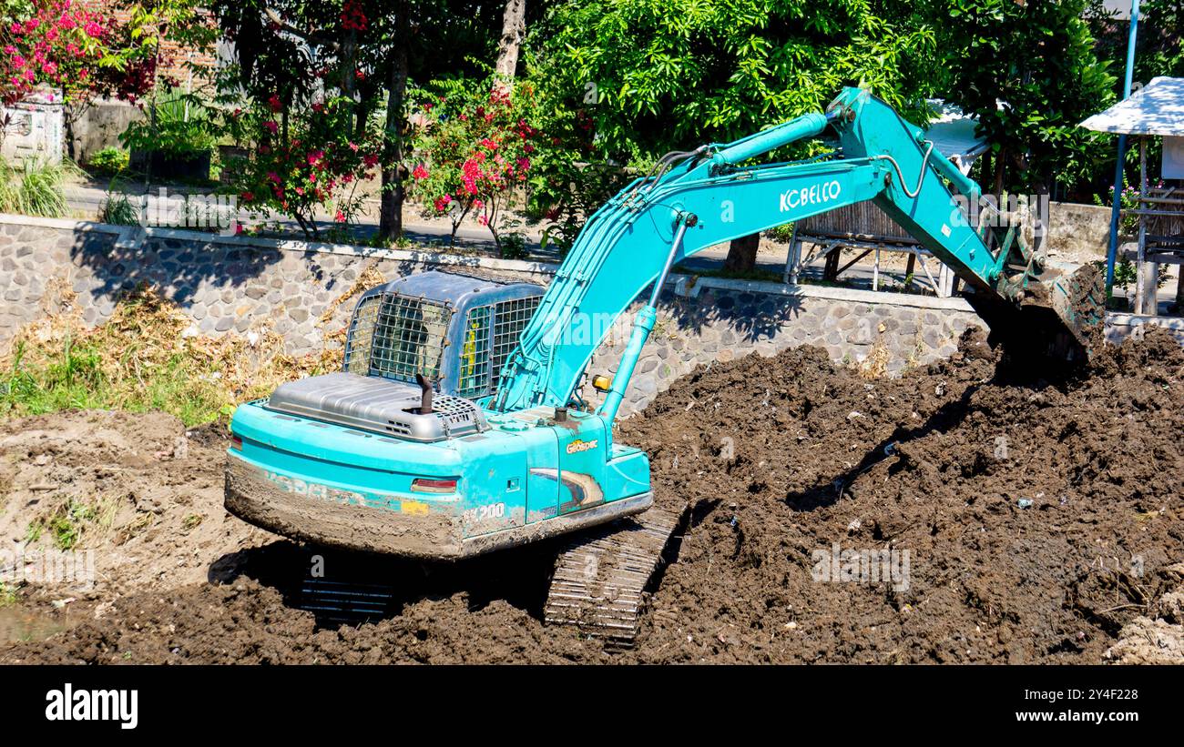 Excavator driver is digging soil in the river to make the water flow ...