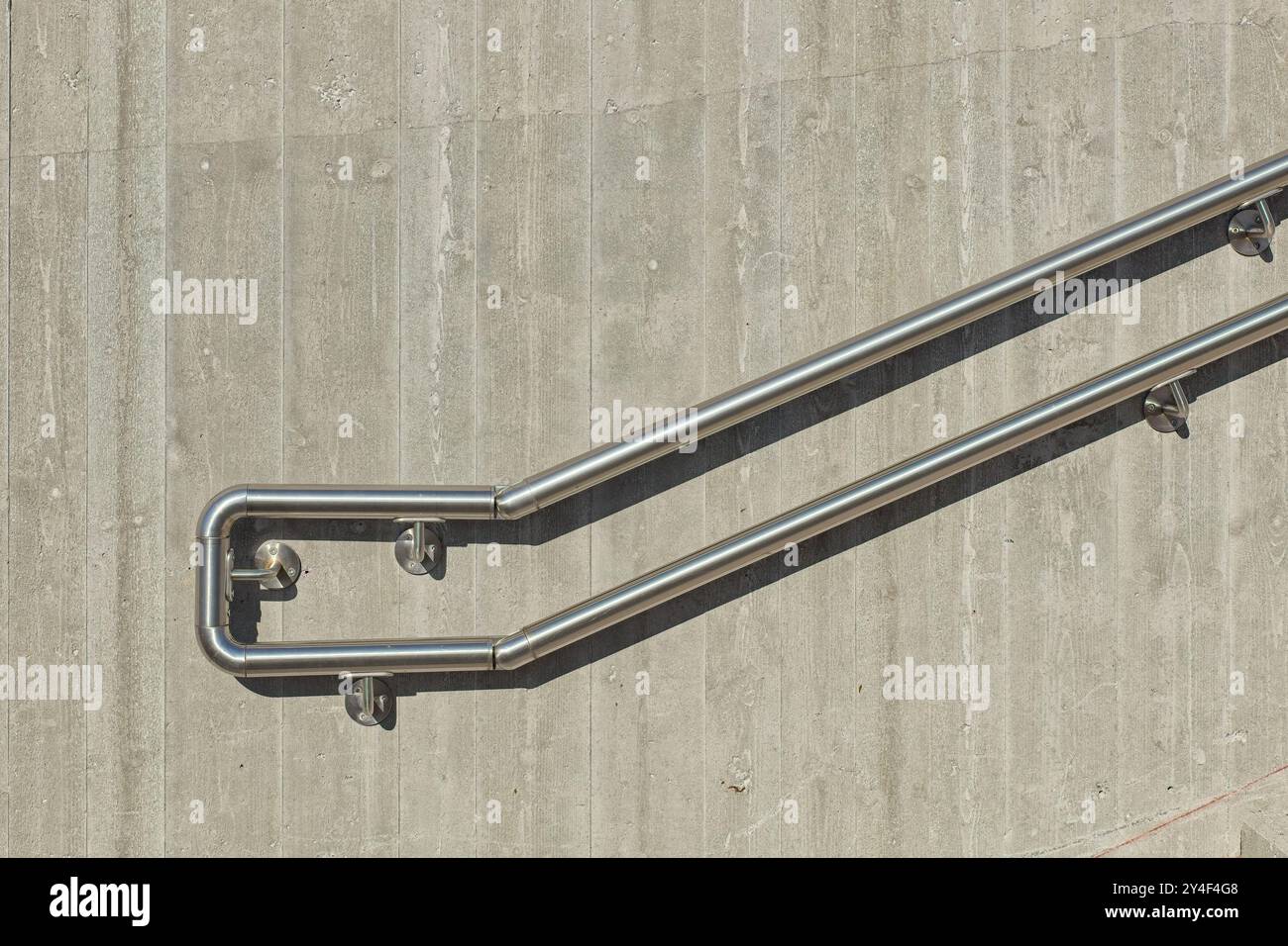 View of concrete wall with metal handrail railing Stock Photo - Alamy