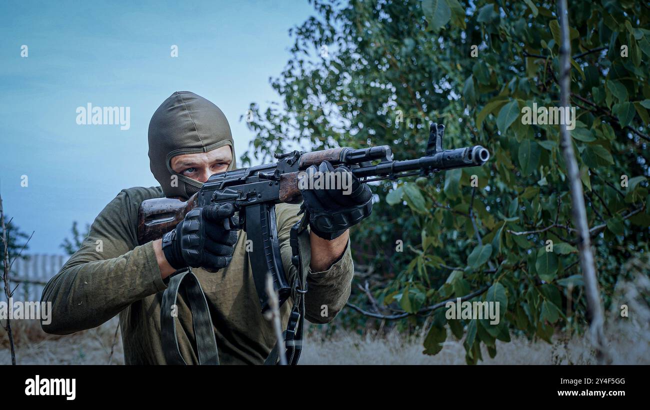 A professional military officer loads his armor and aims his machine ...