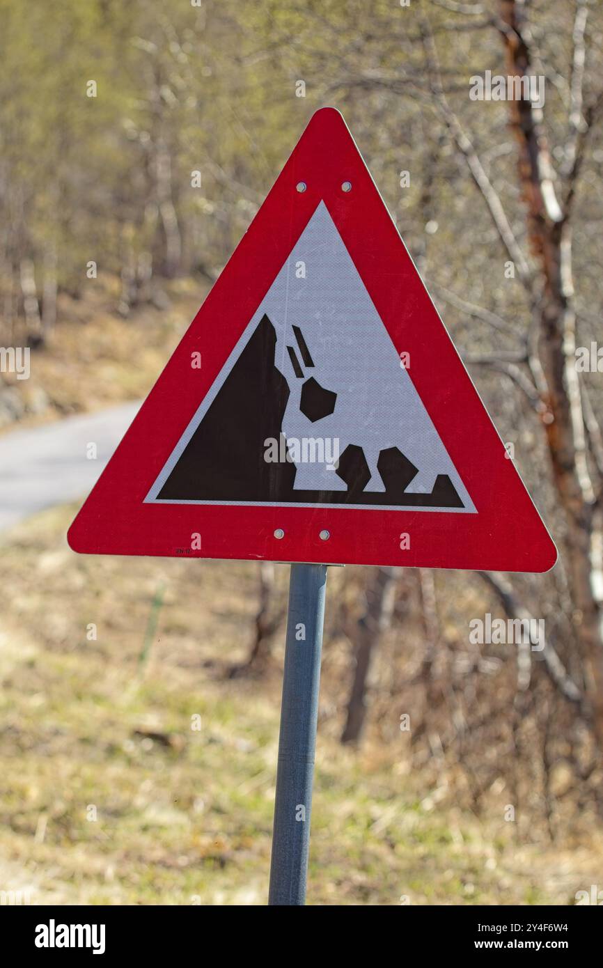 A red triangle sign indicating falling rocks on a white background ...