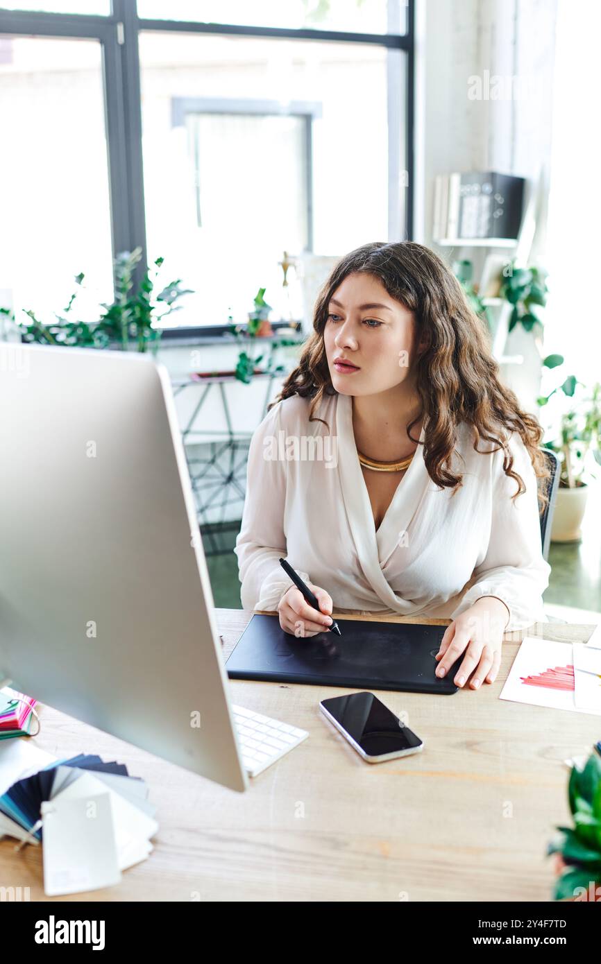 A plus size woman sits at a desk, focused on her creative project in a ...