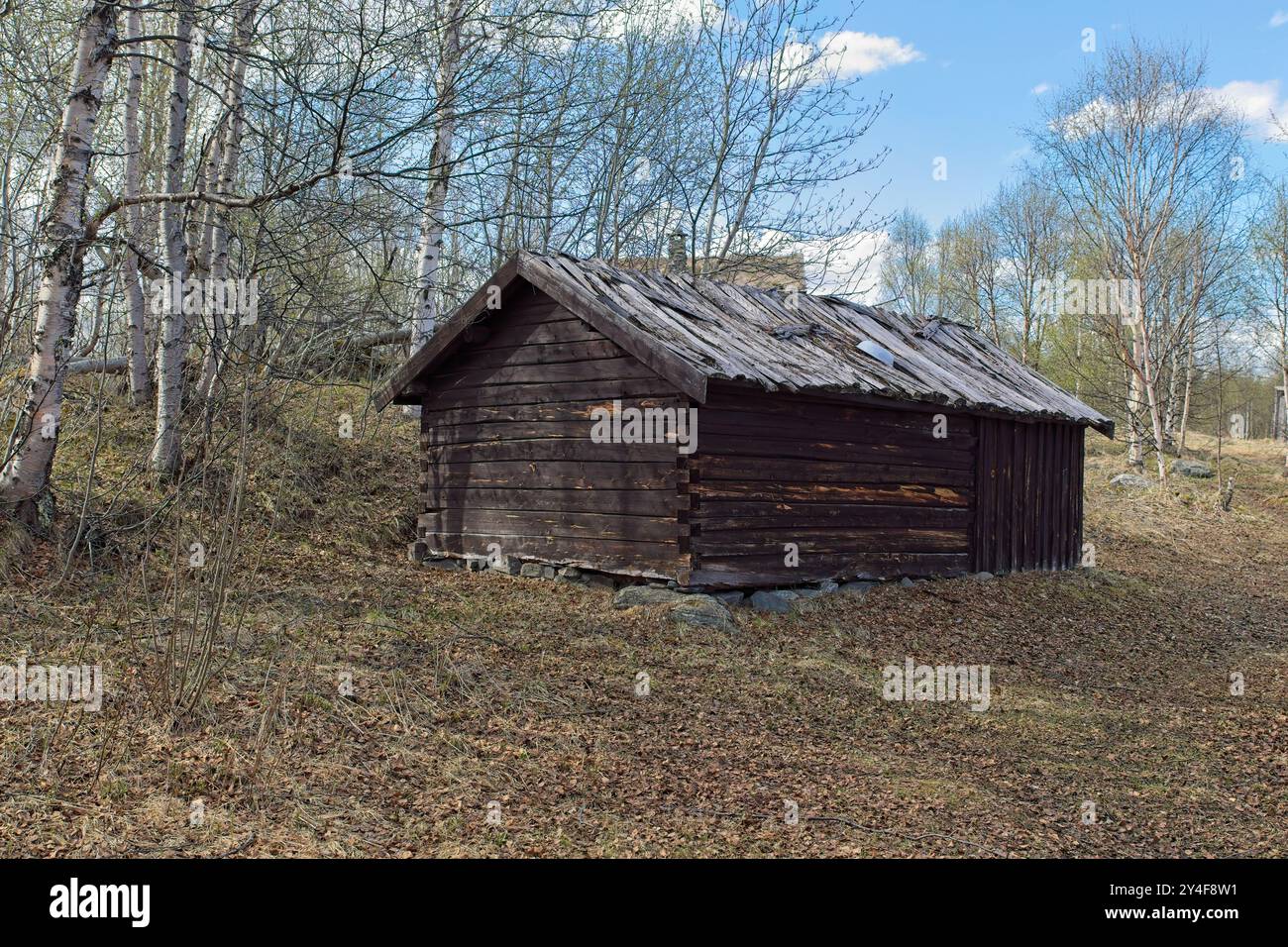 Old timber building at Bjorklund farm museum in spring with clouds in ...