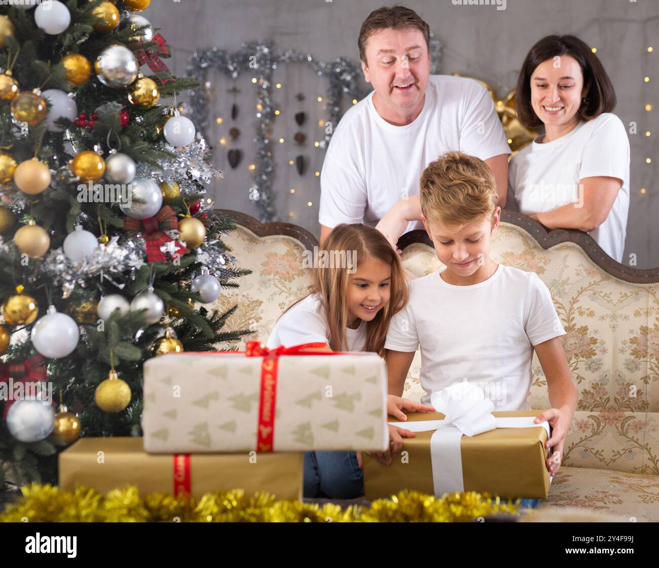 Family with children holding gifts in christmas interior Stock Photo ...