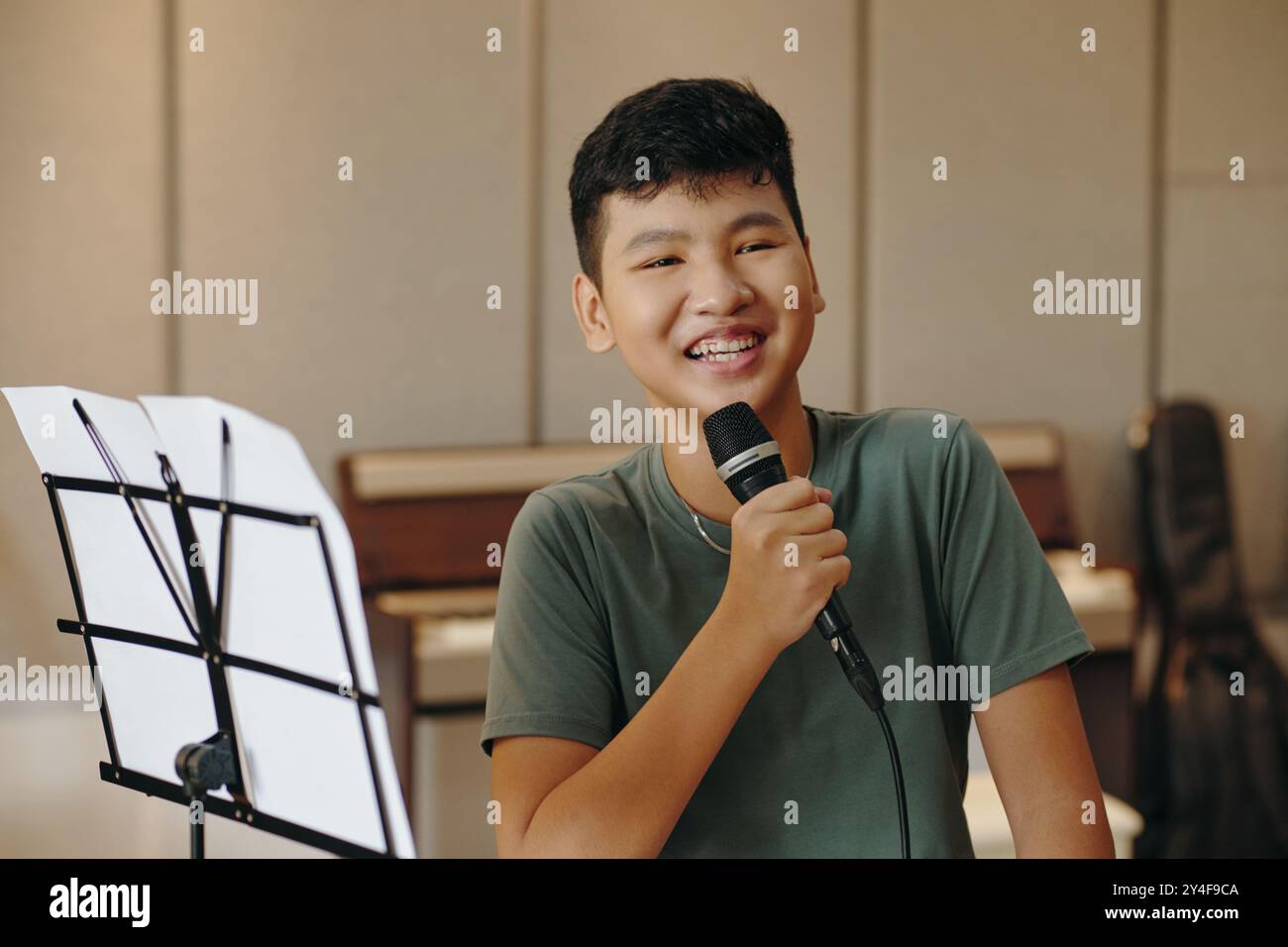 Portrait of Smiling Teenage Boy Holding Microphone Stock Photo - Alamy