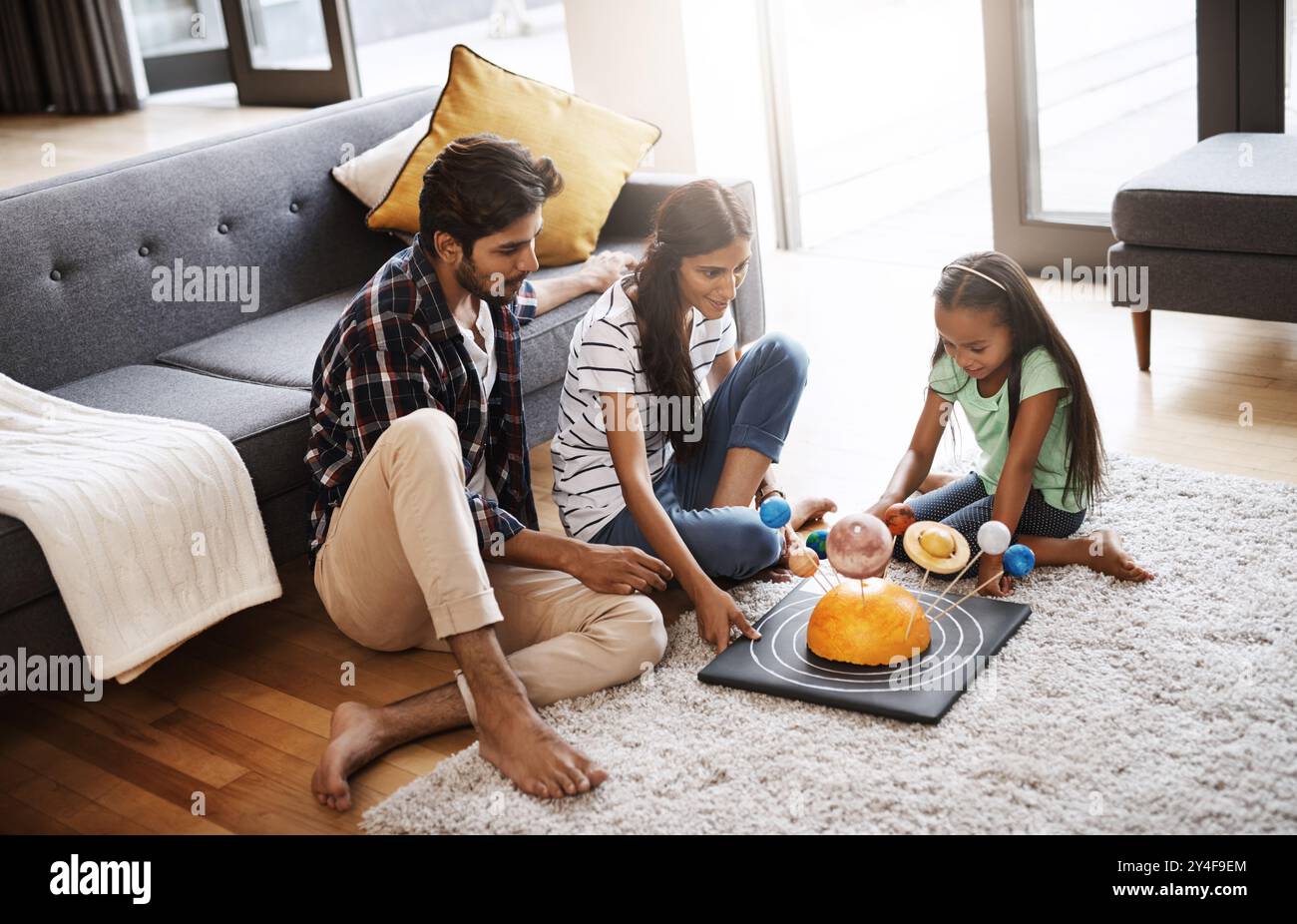 Parents, girl and smile for science homework with universe toys for ...