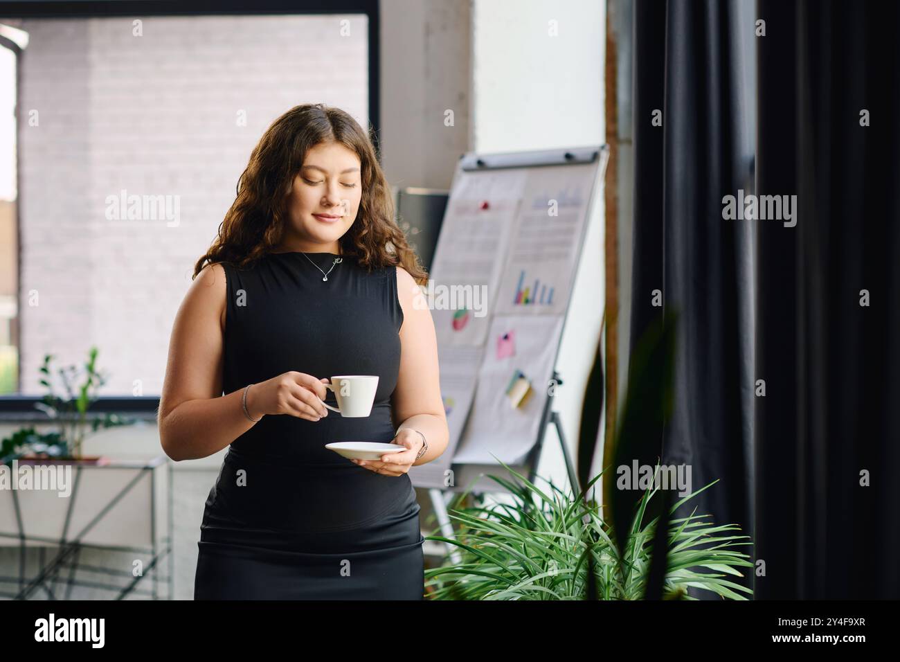 A young and beautiful plus size woman with long curly hair takes a ...