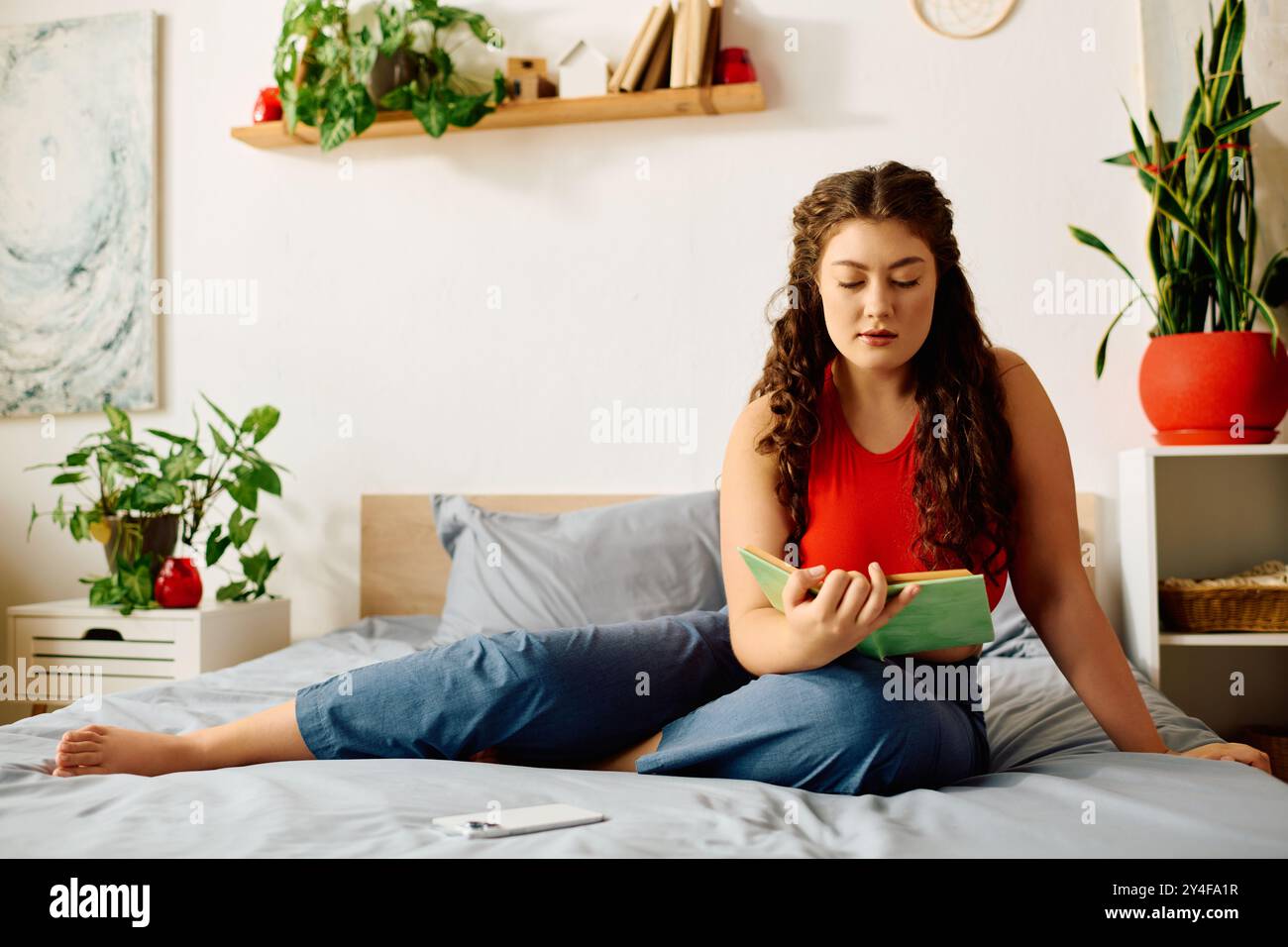 A beautiful plus size woman relaxes in her cozy bedroom, immersed in a ...