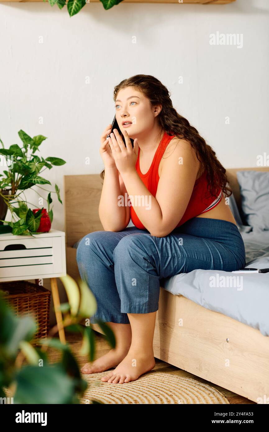 A plus-size woman sits comfortably in her living space, lost in thought ...