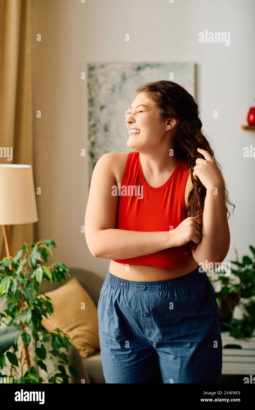A delightful young woman with curly hair smiles as she embraces her ...