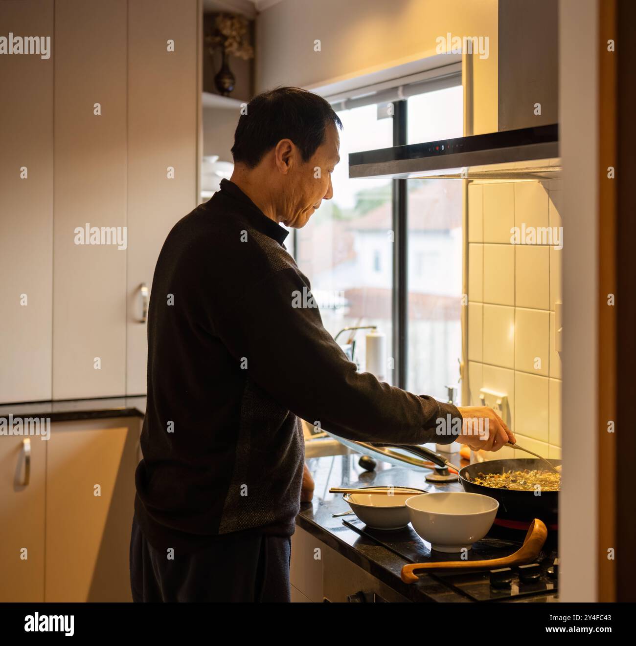 Man cooking dinner on the stovetop in the kitchen Stock Photo - Alamy