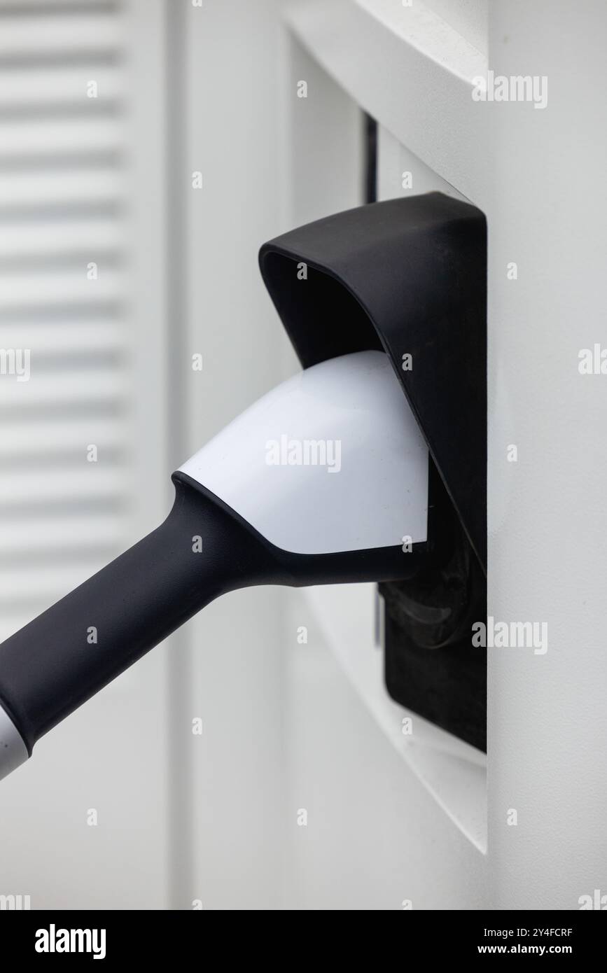 Closeup EV charger handle plugged in or connect to electric car ...