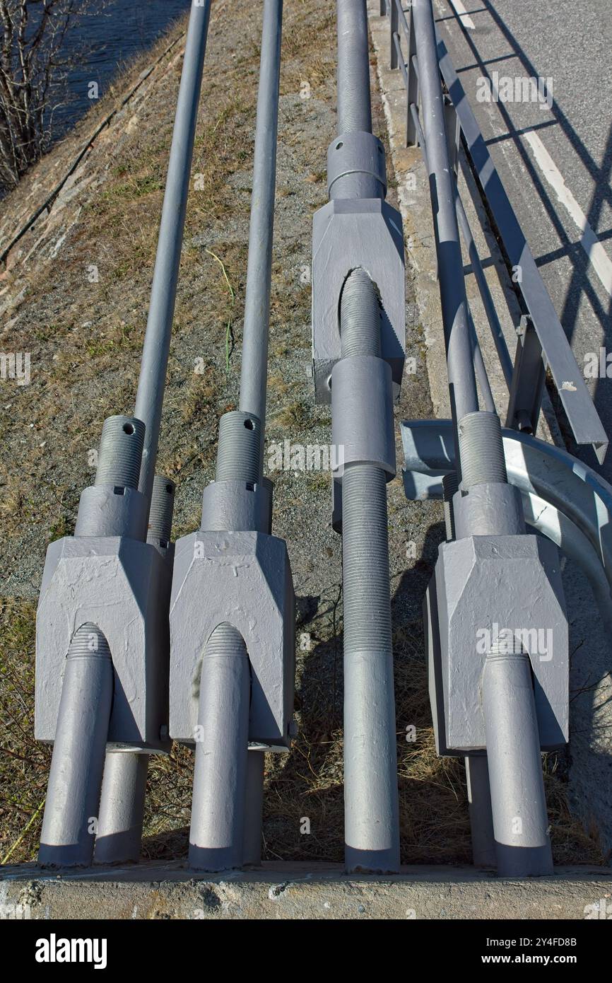 Closeup of suspension bridge cables fastened into concrete for asphalt ...