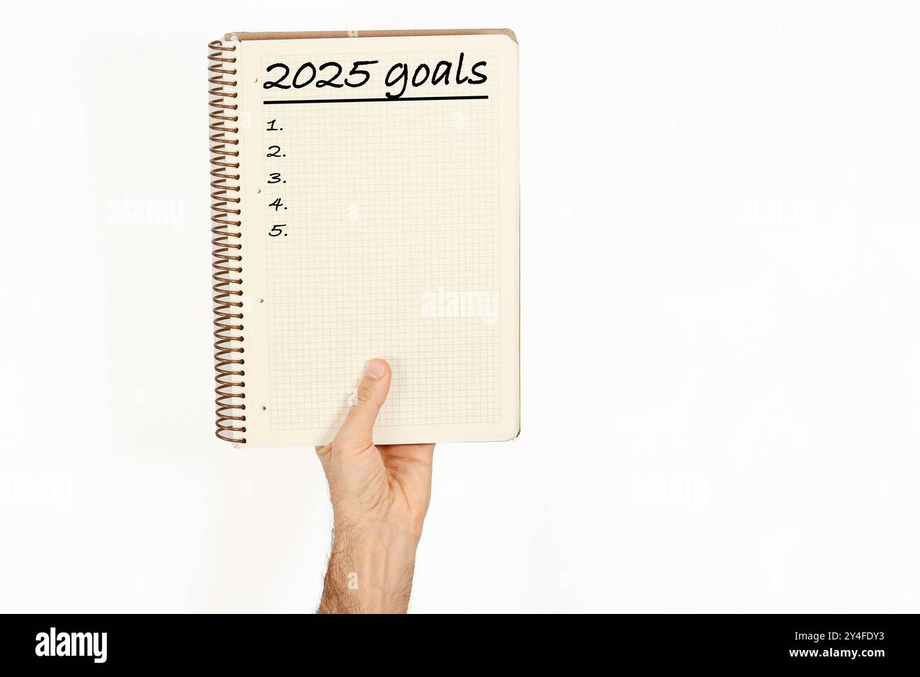2025 goals written on a notebook held by a man. Isolated on white ...