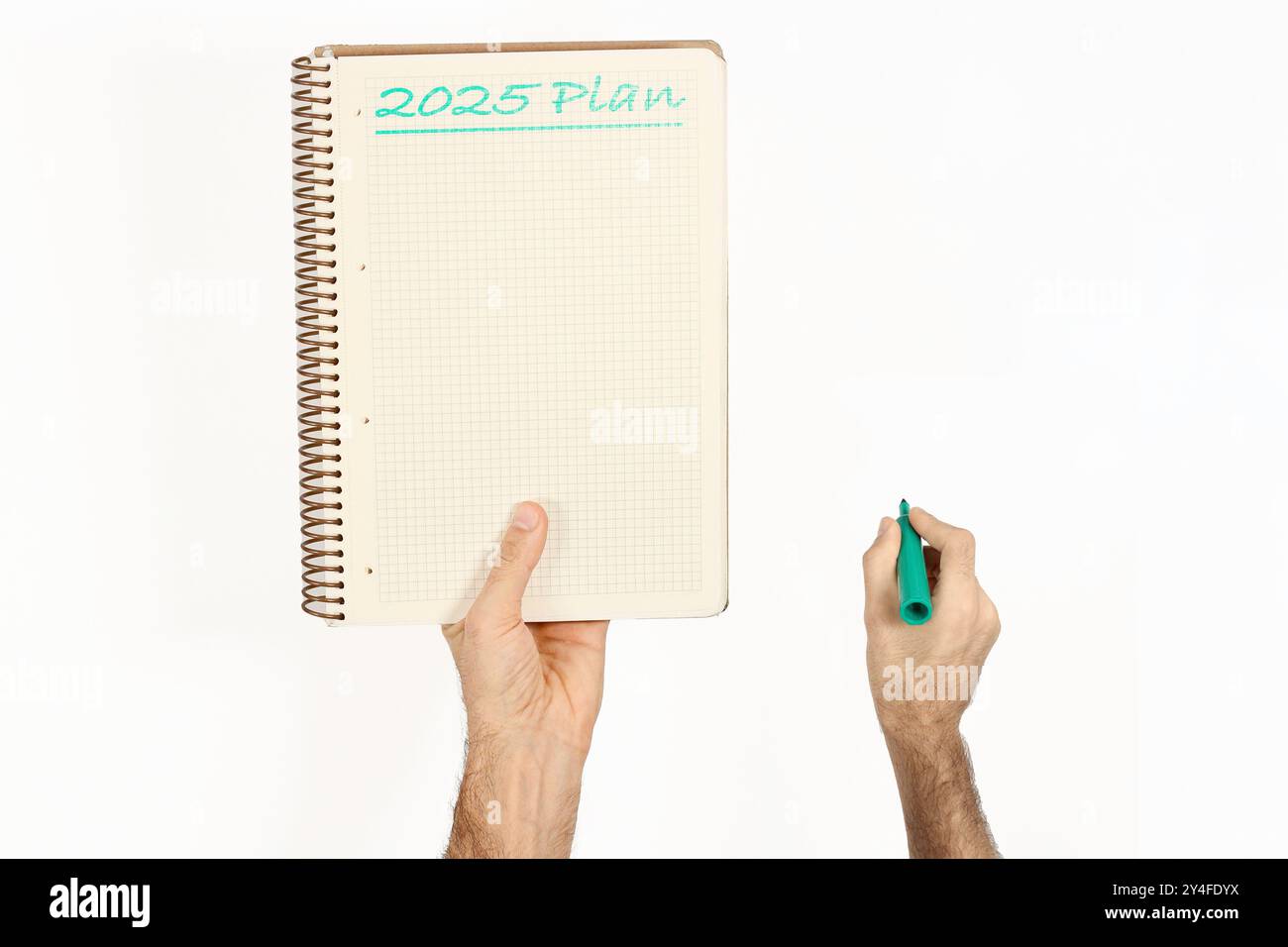 2025 Plan written by green marker on a notebook held by a man. Isolated ...