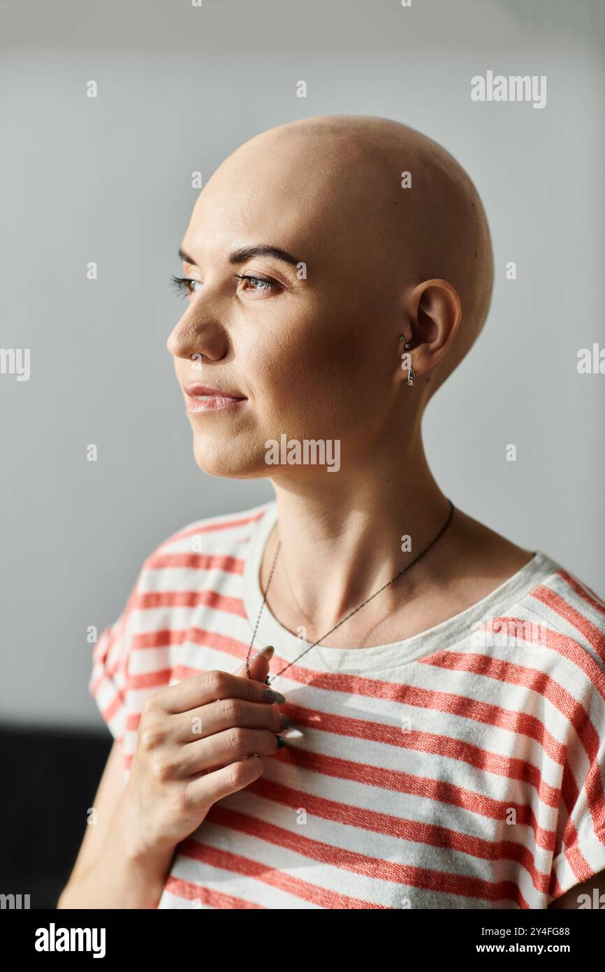 A young bald woman stands thoughtfully, showcasing her beauty and ...