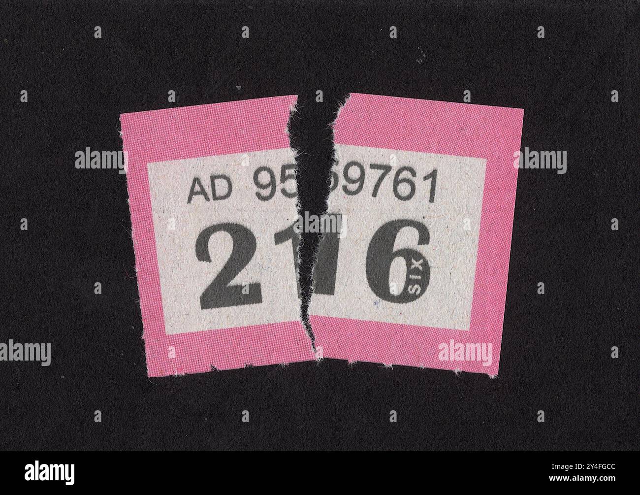 A raffle ticket torn in half on a black background Stock Photo - Alamy