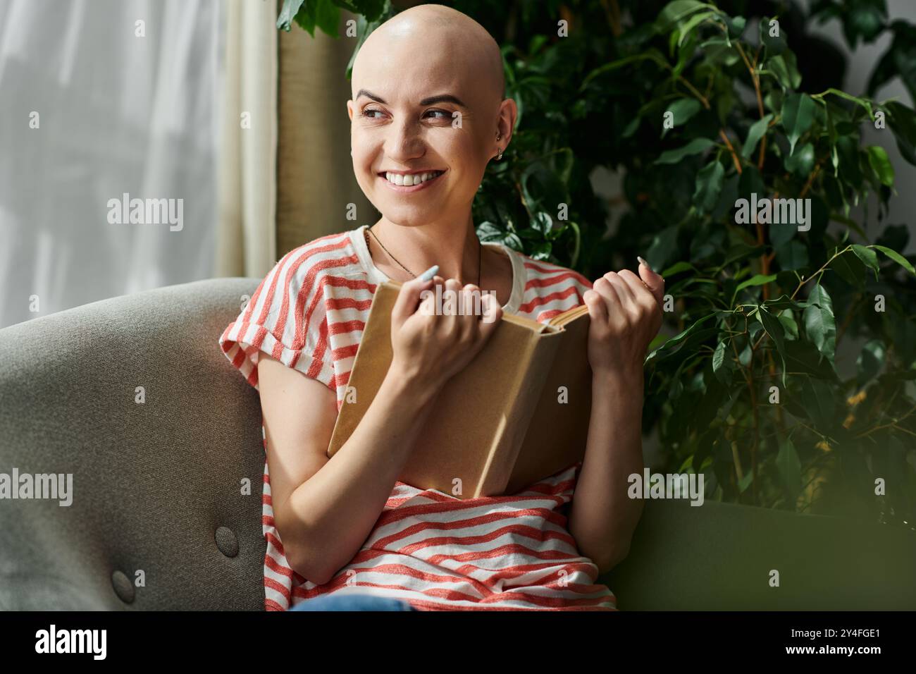 A young, beautiful bald woman smiles brightly while writing in her ...