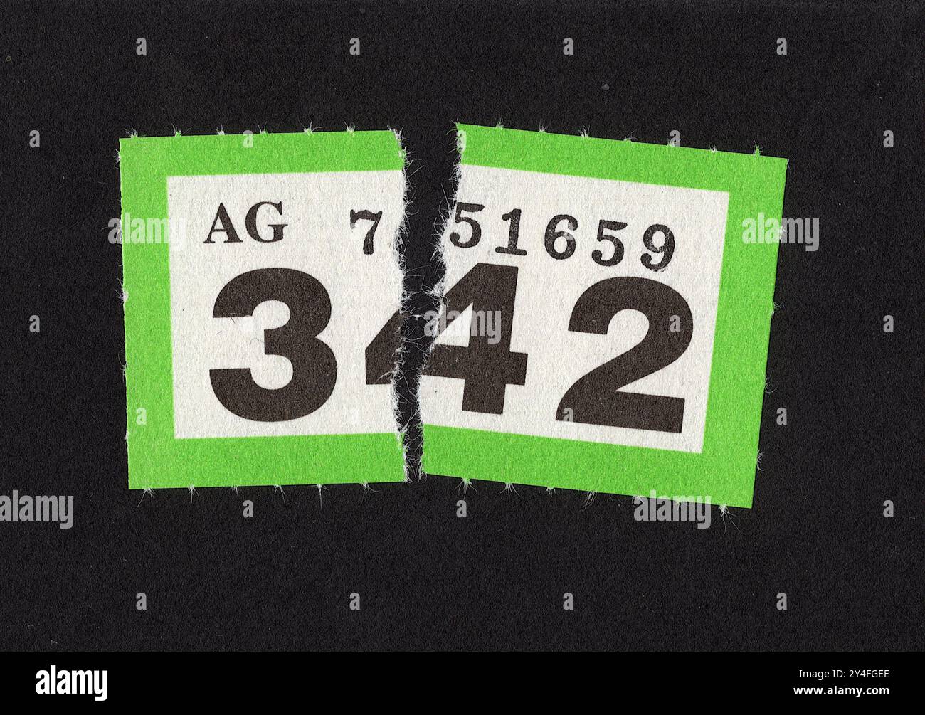 A raffle ticket torn in half on a black background Stock Photo - Alamy