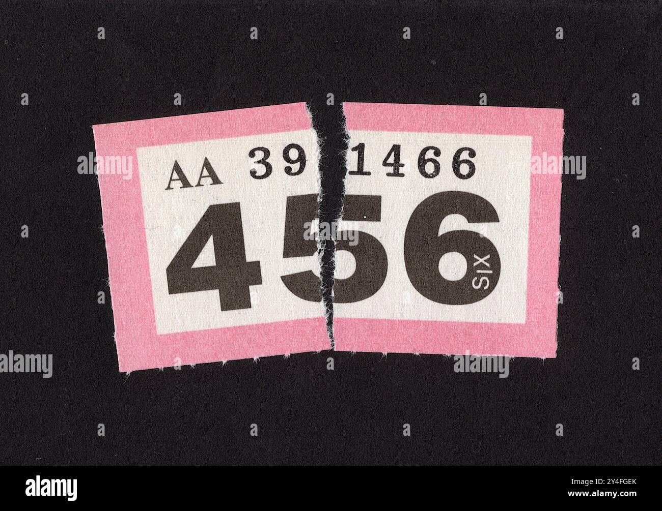A raffle ticket torn in half on a black background Stock Photo - Alamy