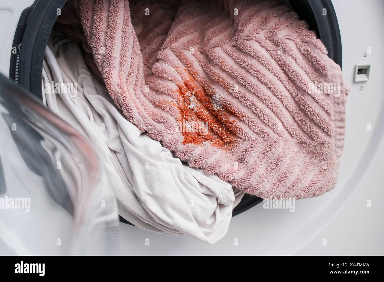 Dirty cloth with a red spot in a washing machine Stock Photo - Alamy