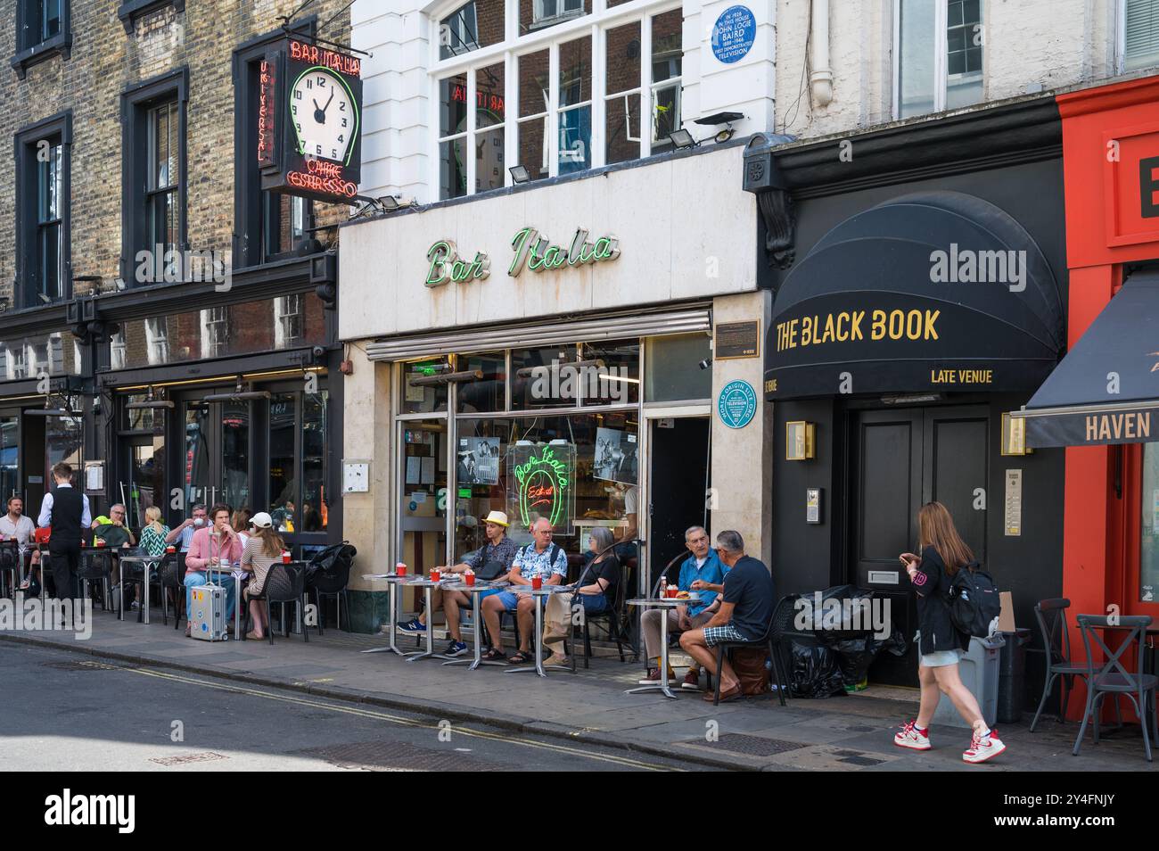 People enjoying food and drink seated at pavement tables outside Bar ...