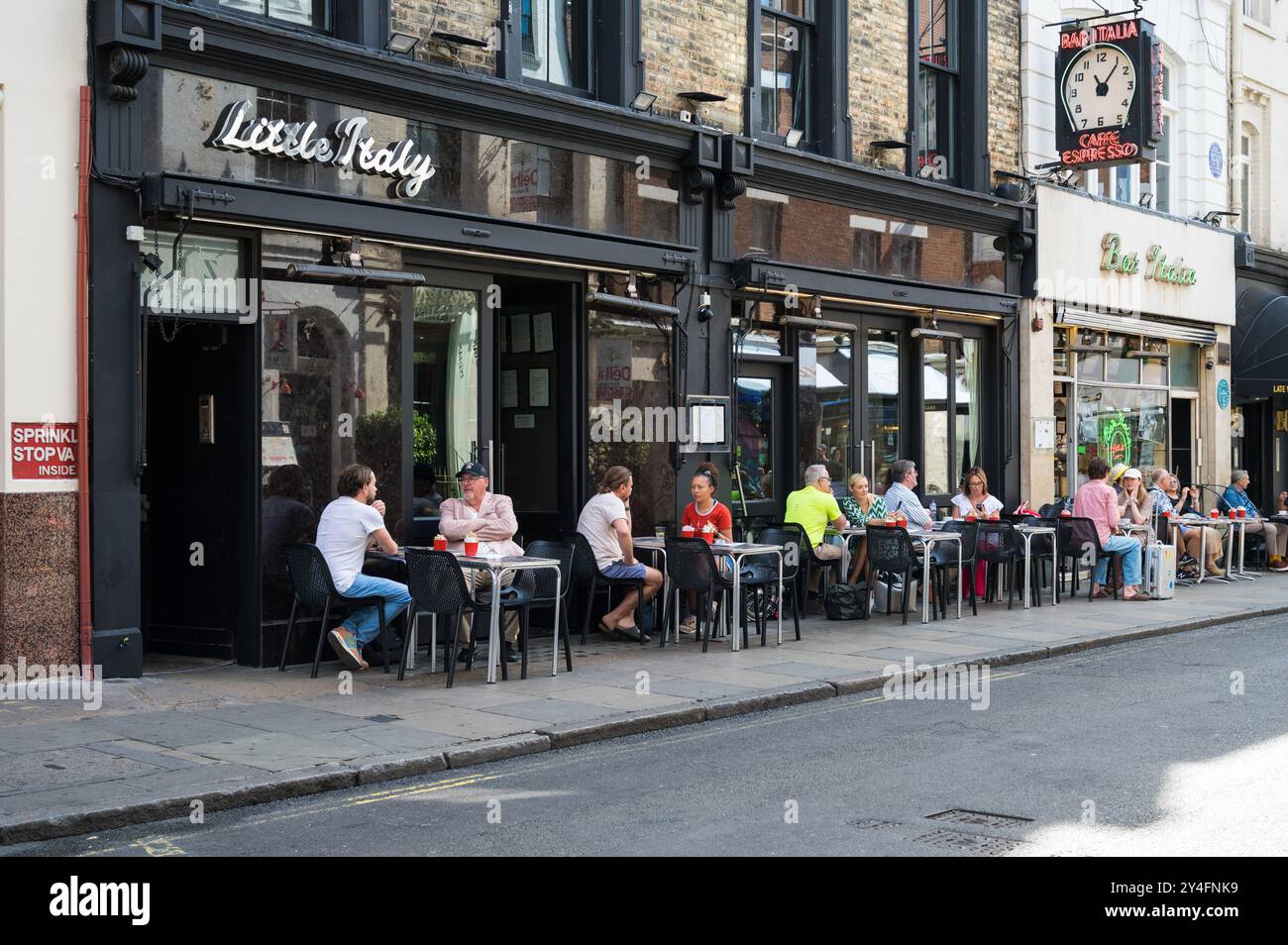 People enjoying food and drink seated at pavement tables outside Bar ...