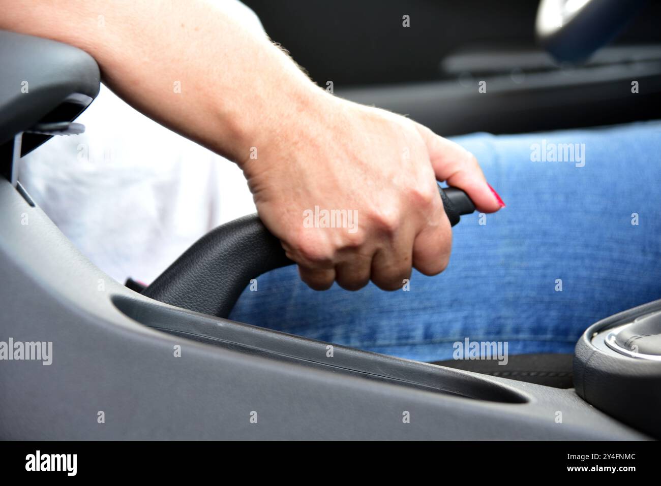 Hand female driver pulling the hand brake inside car Stock Photo - Alamy