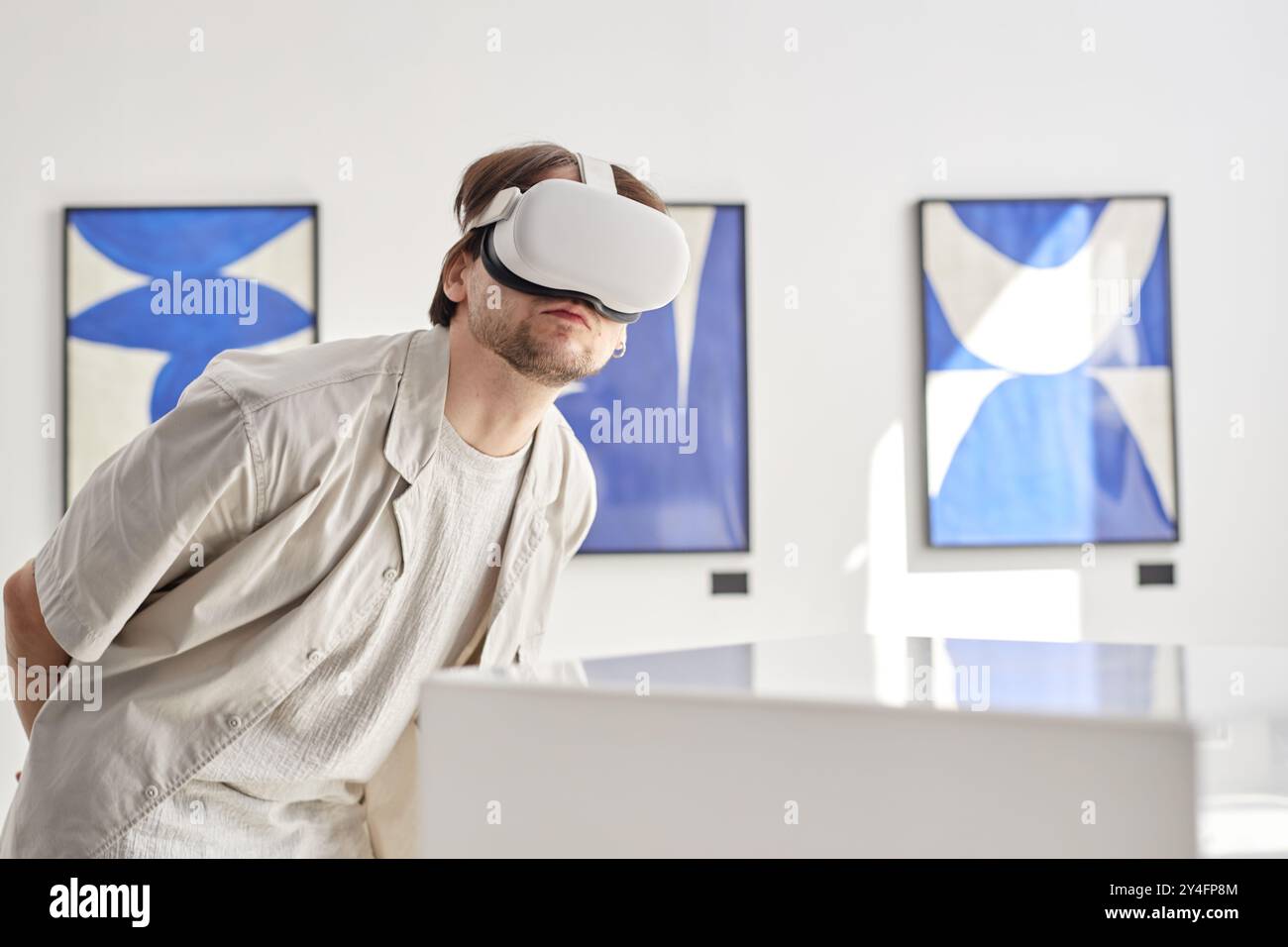 Minimal portrait of man wearing VR looking at invisible digital artwork ...