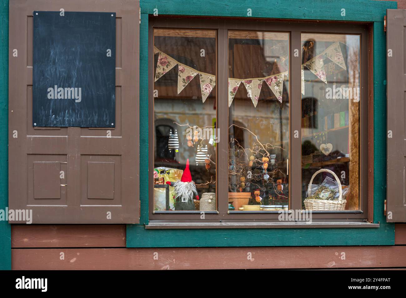 A welcoming shop window displays handmade crafts and seasonal ...
