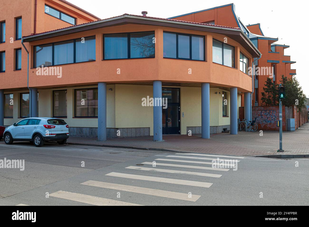 A contemporary building stands next to a crosswalk in a bustling urban ...