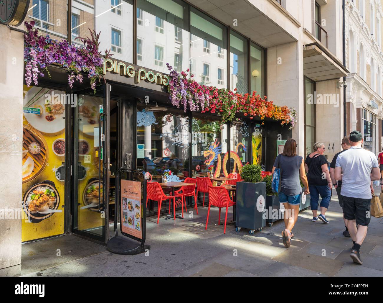 People walking past the colourful exterior of Ping Pong Chinese ...