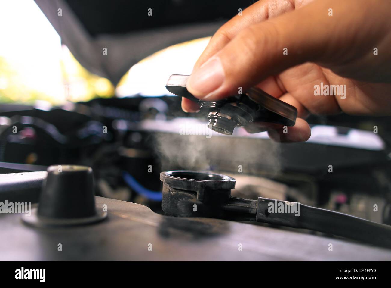The mechanic opened the car radiator cap and steam came out ...